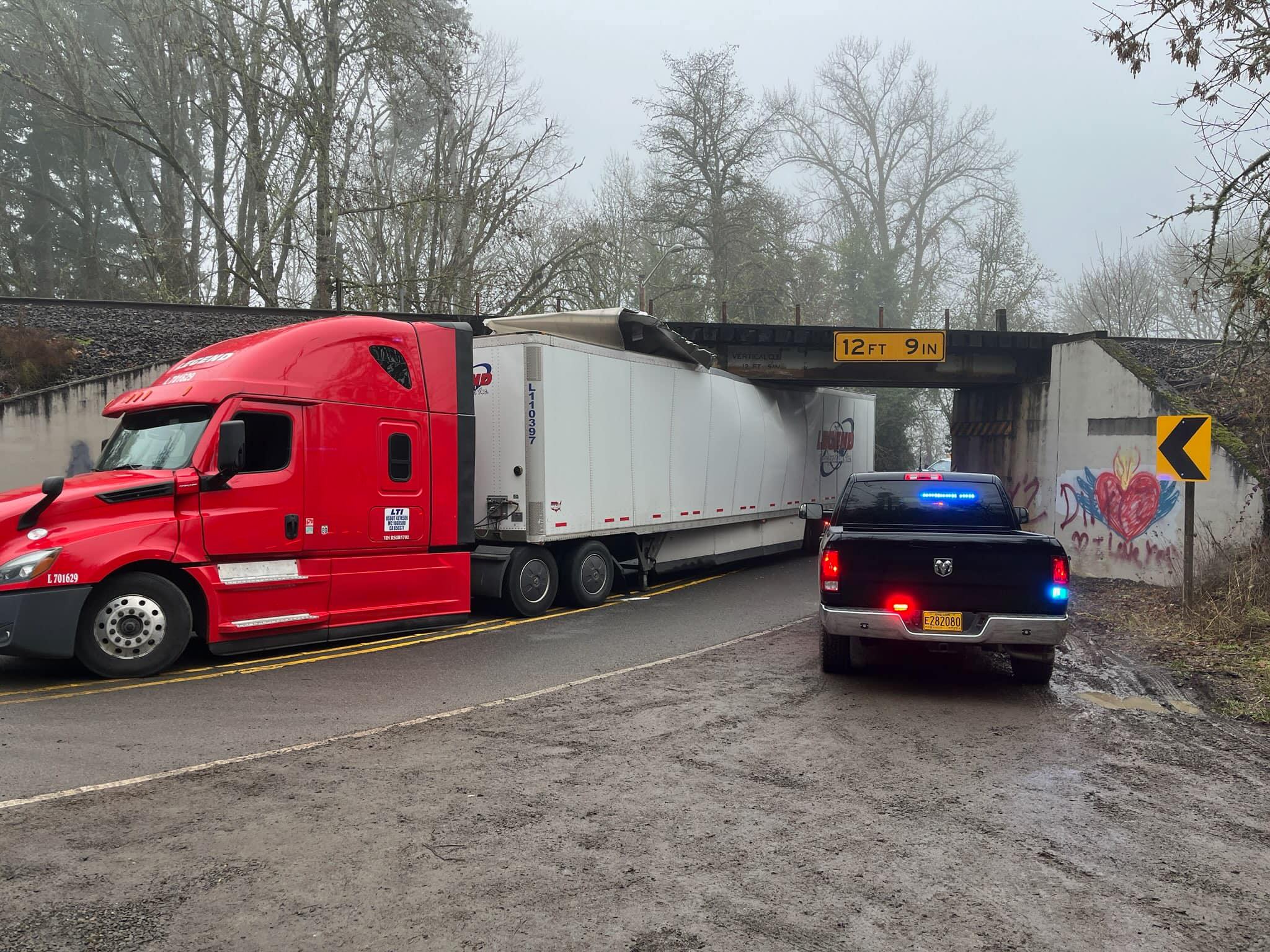 River Road reopened after hours closed due to semi truck stuck under ...